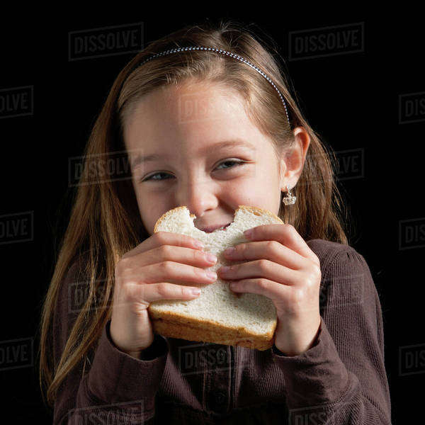 Young girl eating a sandwich - Royalty-free Stock Photo | Dissolve