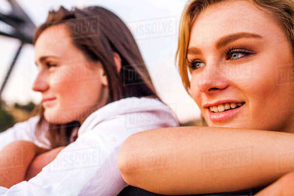 Caucasian teenage girls leaning on banister together - Royalty-free Stock Photo | Dissolve