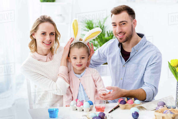 Celebrating family with daughter playing with easter bunny ears by ...