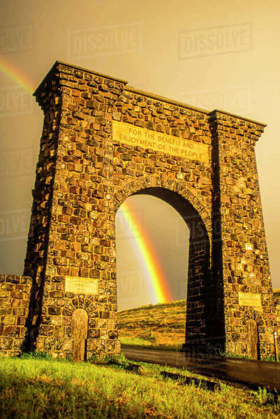 Roosevelt Arch with a stunning rainbow at the north entrance to Yellowstone National Park in ...