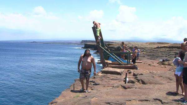 People at South Point, Ka Lae on the Big Island show off their skills and jump off the cliff ...