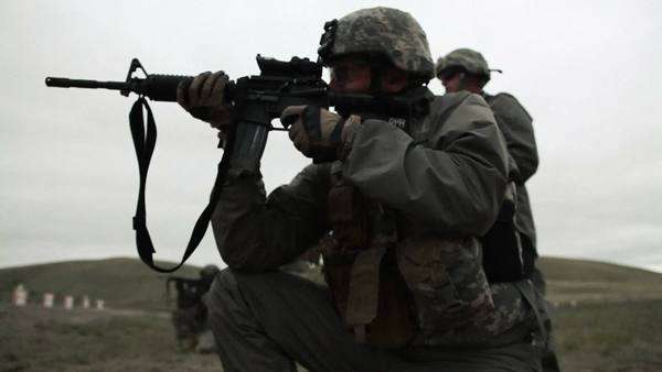 Stylized high contrast static shot of soldier shooting M4 rifle at ...