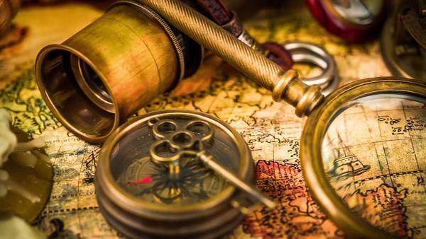 Vintage magnifying glass, compass, telescope and a pocket watch lying ...