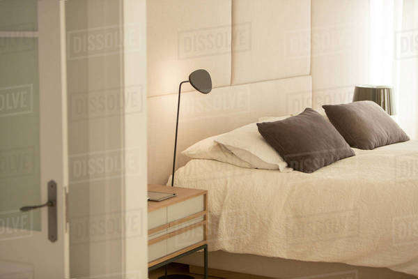 Illuminated lamp over bed - Royalty-free Stock Photo | Dissolve