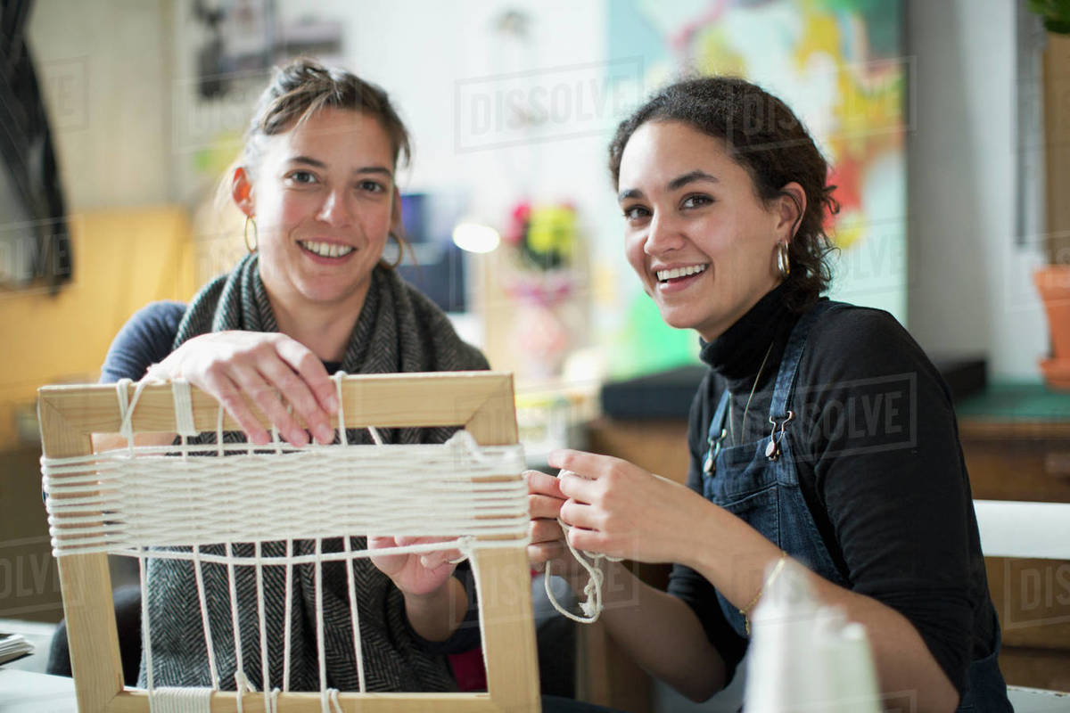 Portrait smiling young women friends making string picture frame ...