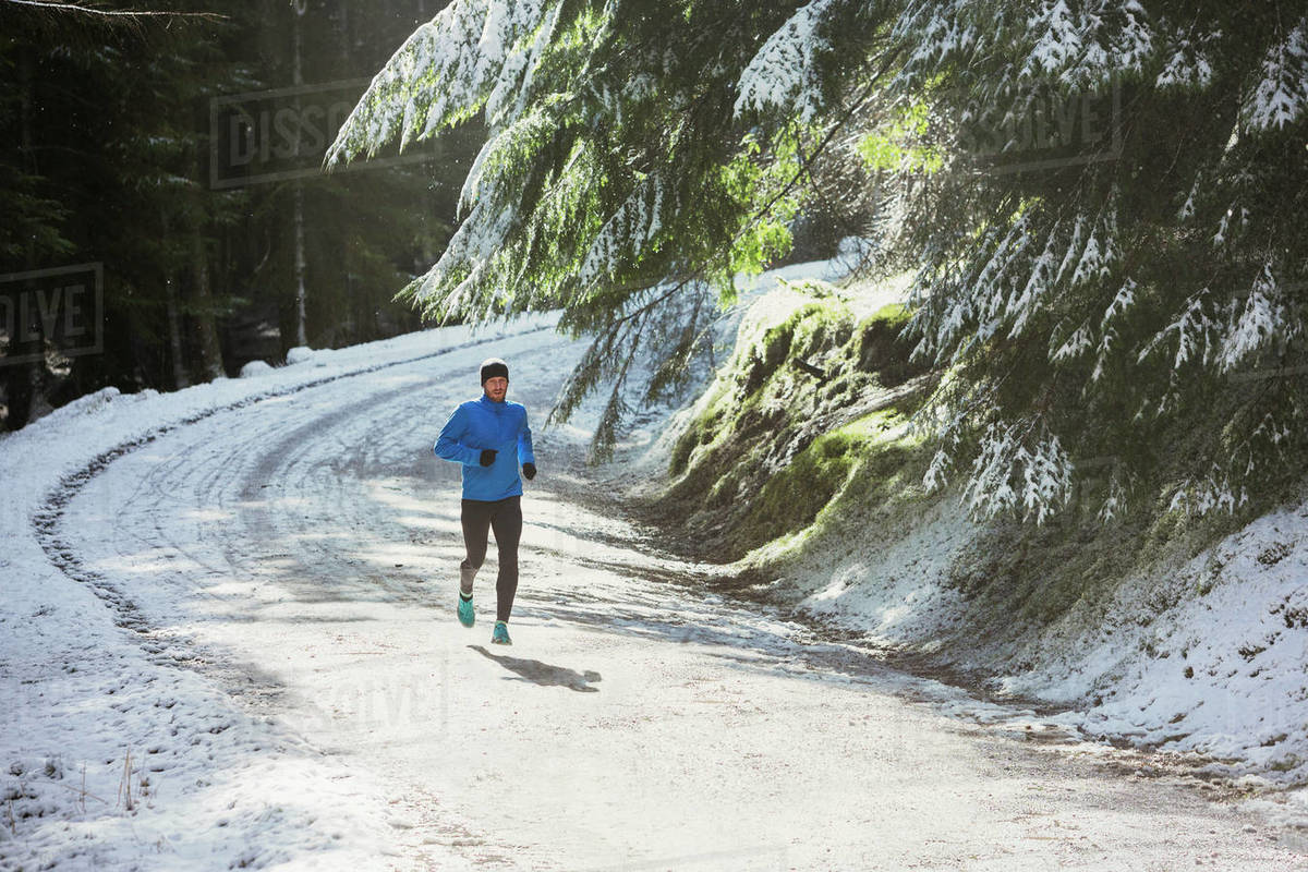 Man jogging in snow - Stock Photo - Dissolve