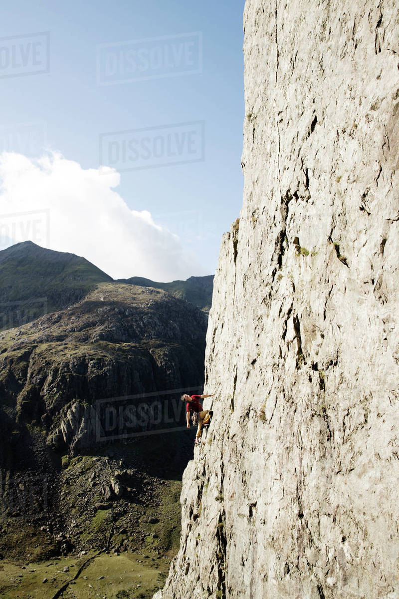 Male rock climber scaling large rock face - Royalty-free Stock Photo ...