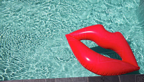 Inflatable lips floating in sunny summer swimming pool - Stock Photo ...