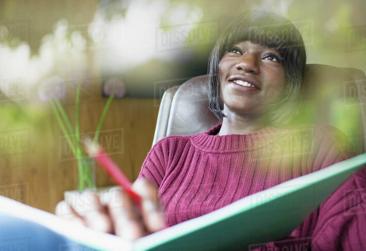 Happy young woman journaling - Royalty-free Stock Photo | Dissolve