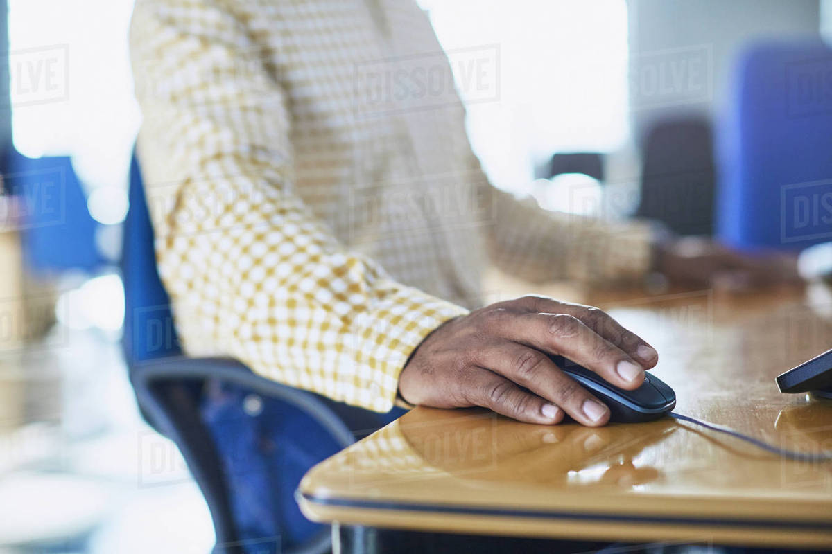 Businessman using computer mouse at desk - Royalty-free Stock Photo ...