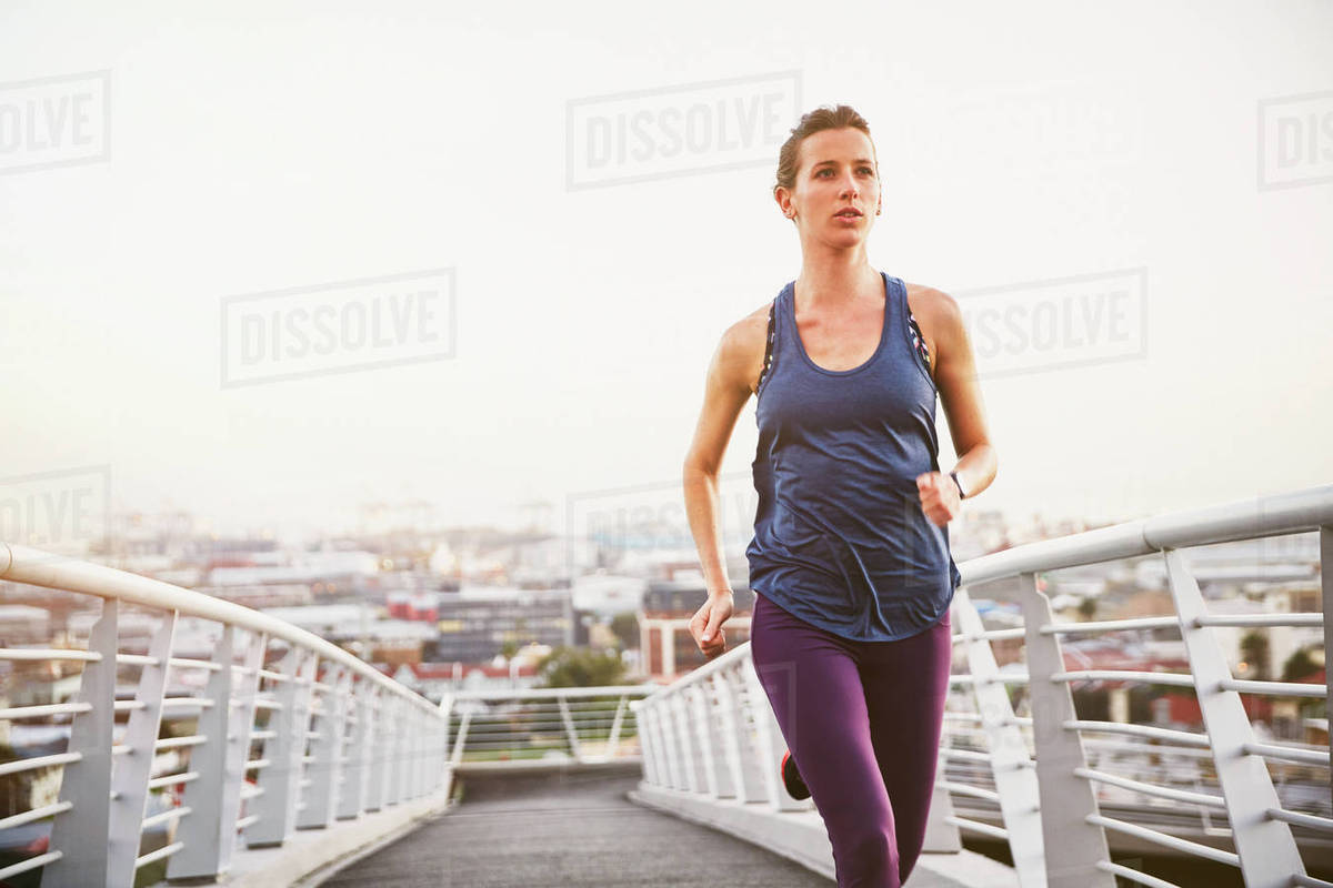 Female runner running on urban footbridge - Royalty-free Stock Photo ...