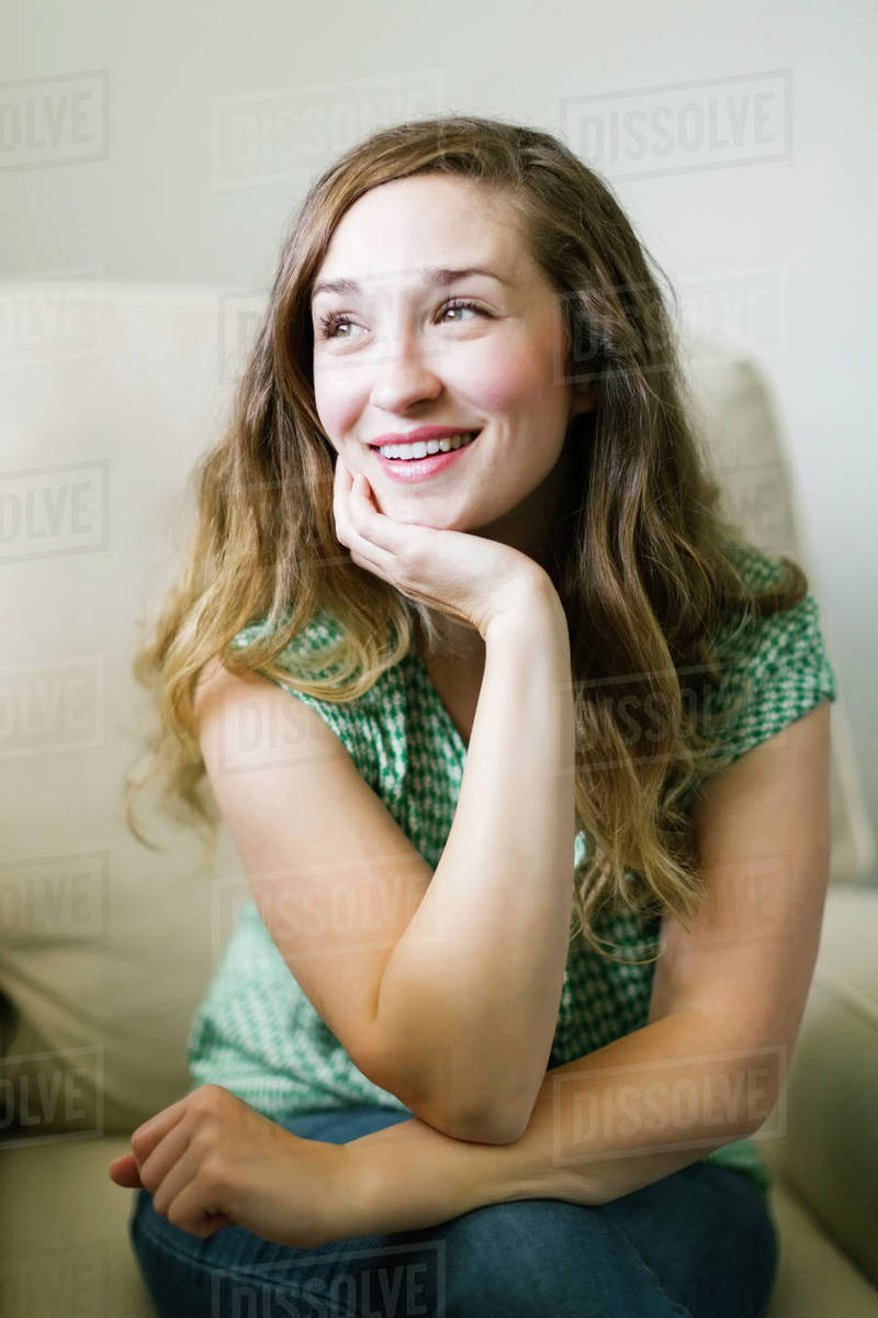 Portrait of woman sitting in living room - Royalty-free Stock Photo ...