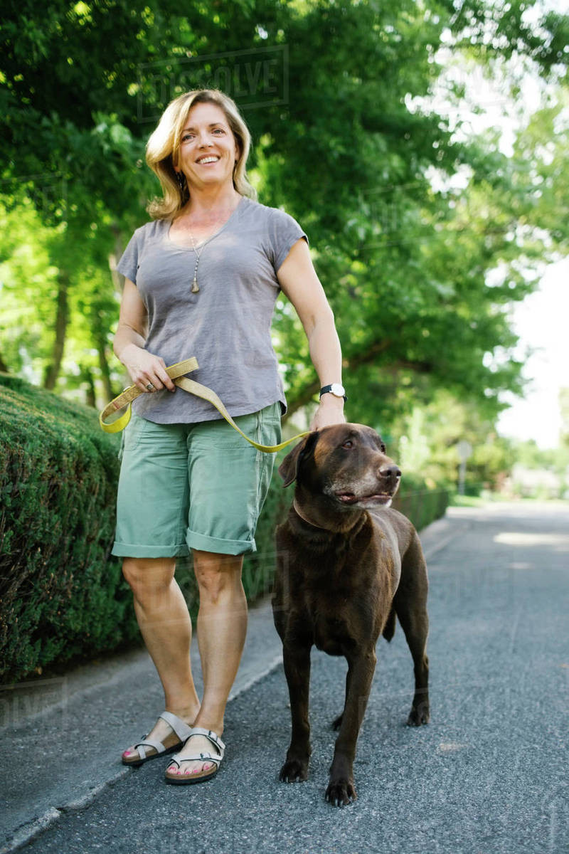 Woman walking with Labrador Retriever - Royalty-free Stock Photo | Dissolve