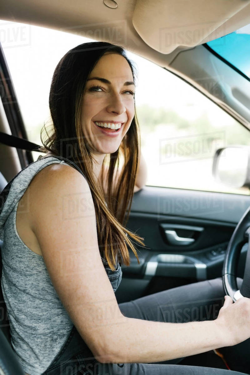 Smiling woman driving car - Stock Photo - Dissolve