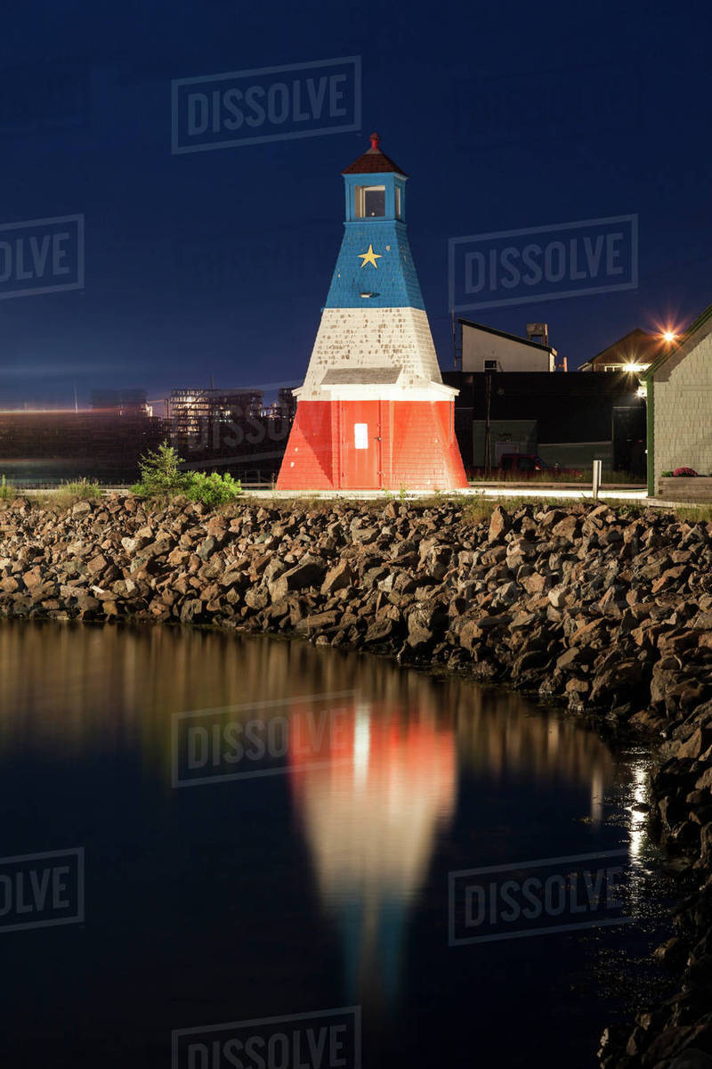 Canada, Nova Scotia, Cheticamp, Lighthouse reflecting in water - Stock ...