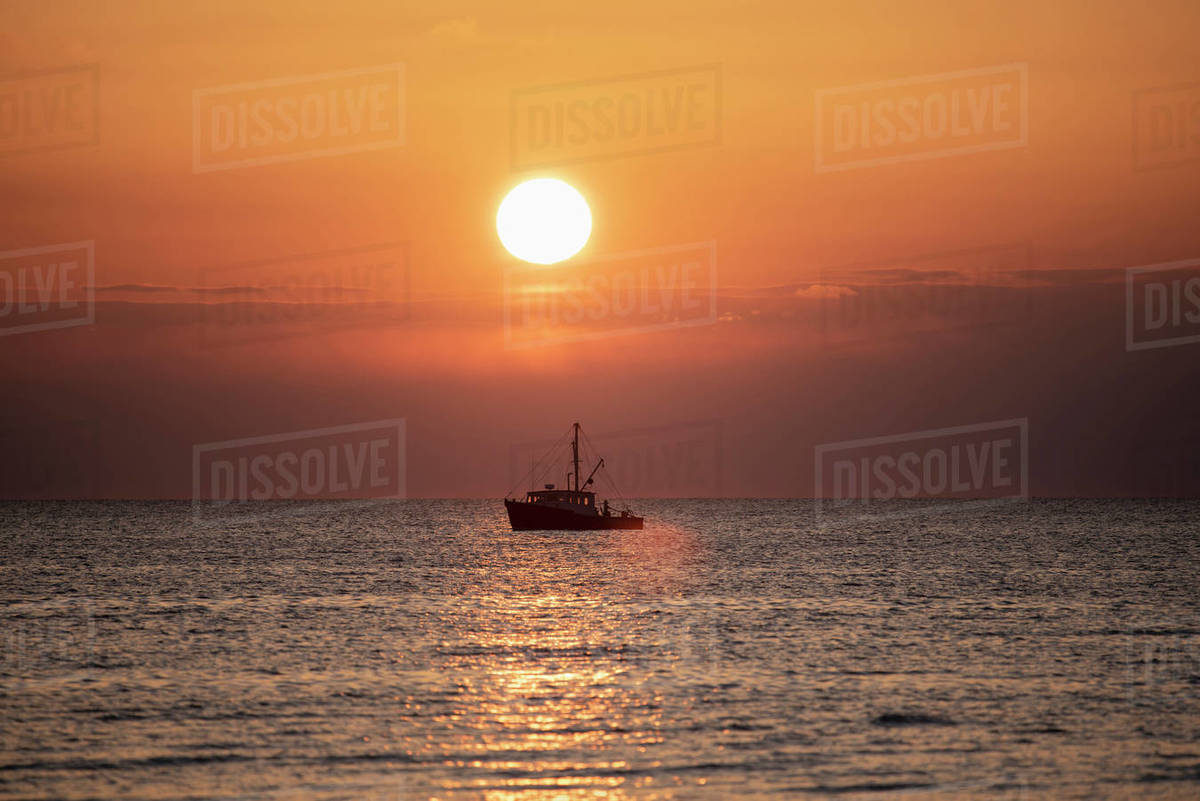 Fishing boat at sunset - Stock Photo - Dissolve