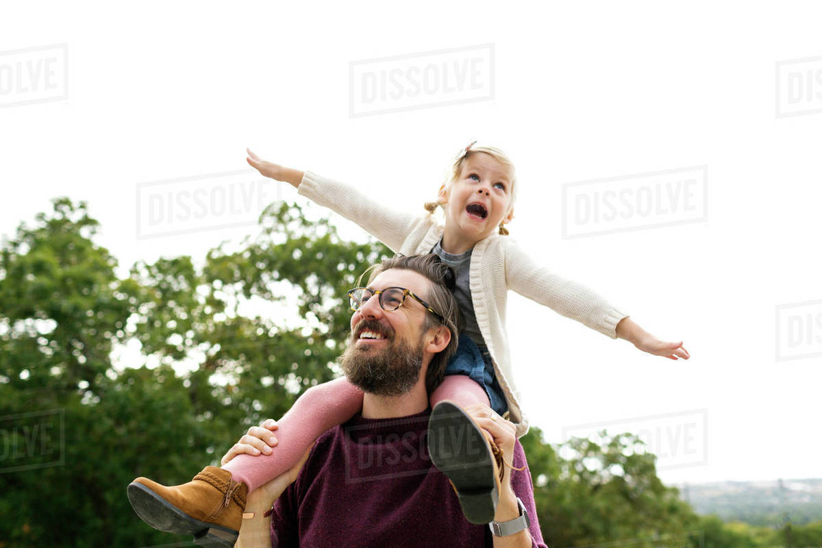 Father giving daughter piggyback ride - Stock Photo - Dissolve