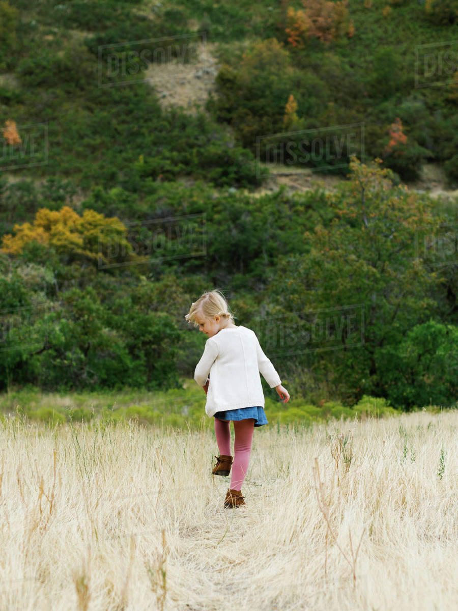 Girl walking in field - Royalty-free Stock Photo | Dissolve