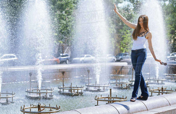 Woman walking by water fountain - Royalty-free Stock Photo | Dissolve