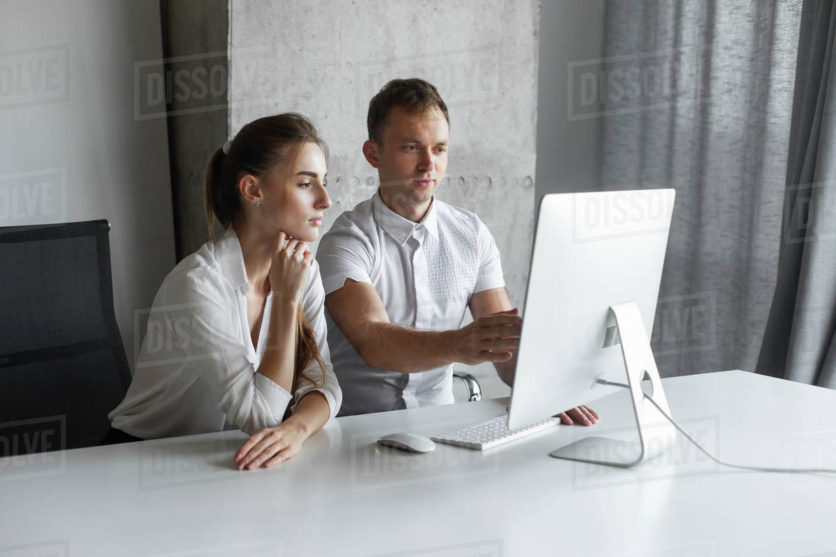 Coworkers working together at desktop computer - Royalty-free Stock ...
