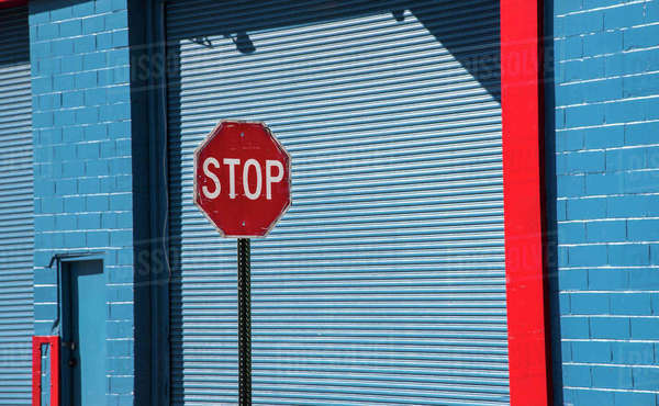 Stop sign by blue garage door - Royalty-free Stock Photo | Dissolve