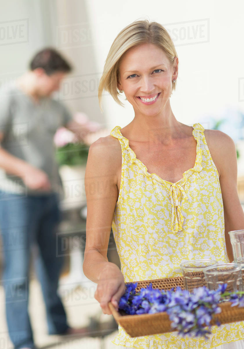 Woman carrying tray with crockery and flowers - Royalty-free Stock ...