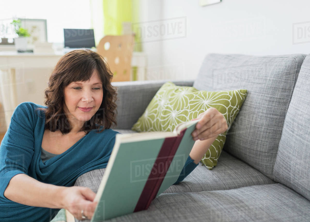 Woman reading book at home - Royalty-free Stock Photo | Dissolve