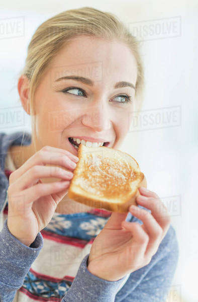 Woman eating toast - Royalty-free Stock Photo | Dissolve