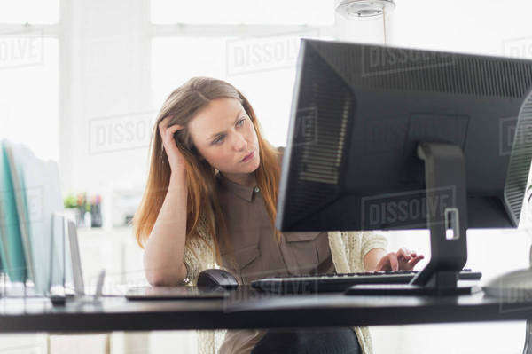 Portrait of young woman working on computer in office - Royalty-free ...