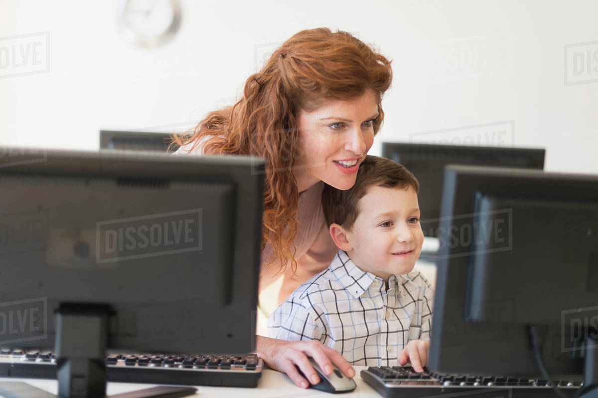 Boy (6-7) and teacher using computer - Royalty-free Stock Photo | Dissolve