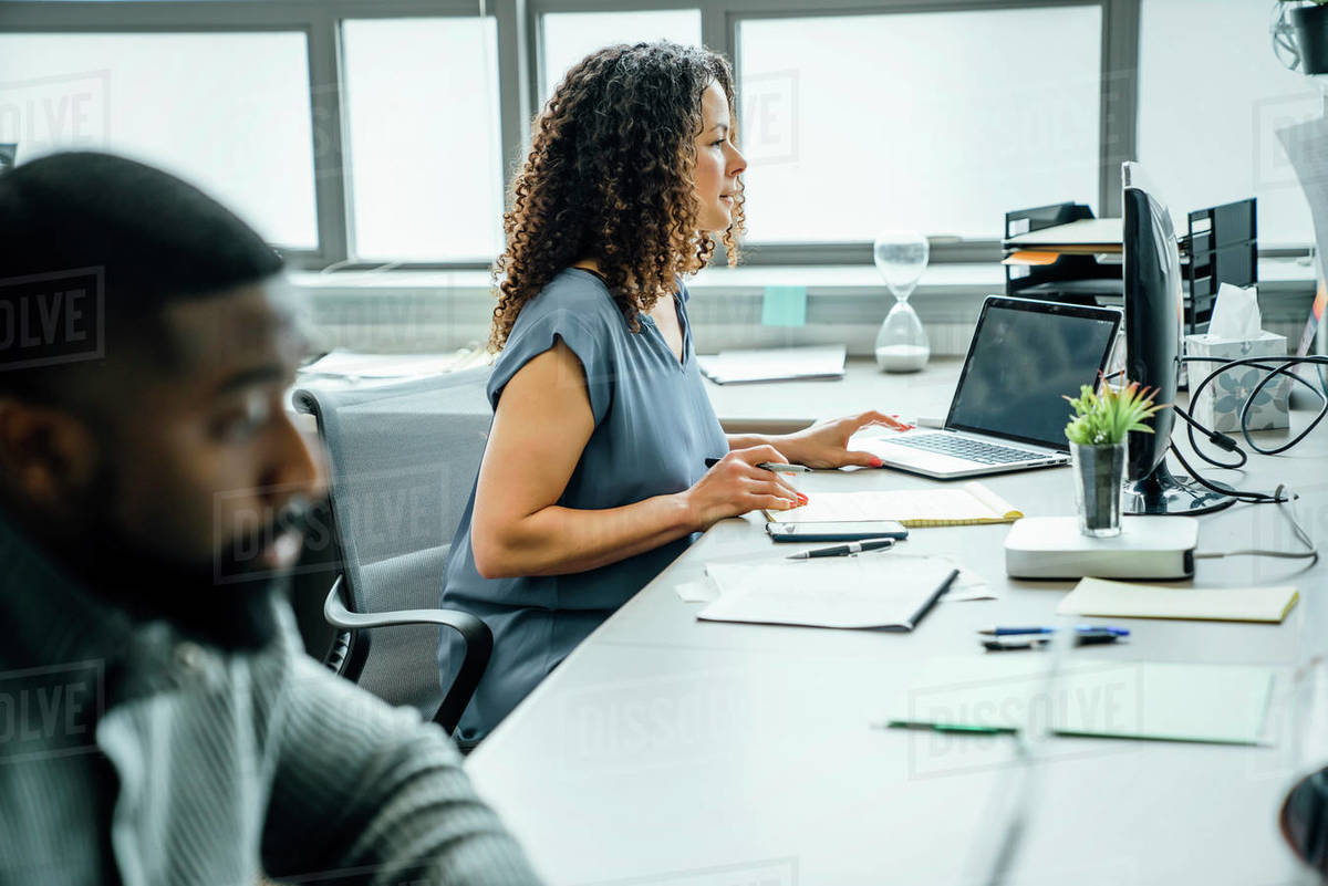 Woman using computer in office - Stock Photo - Dissolve