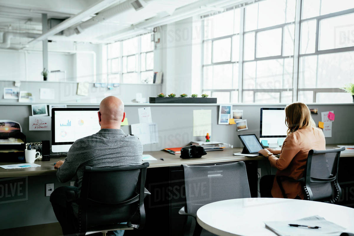 Workers using computers in office - Royalty-free Stock Photo | Dissolve