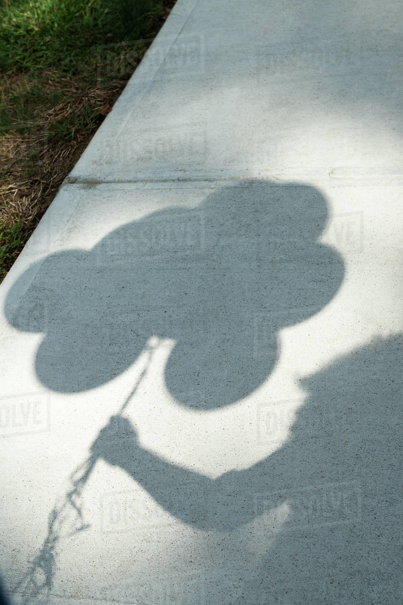Shadow of girl holding balloons - Royalty-free Stock Photo | Dissolve