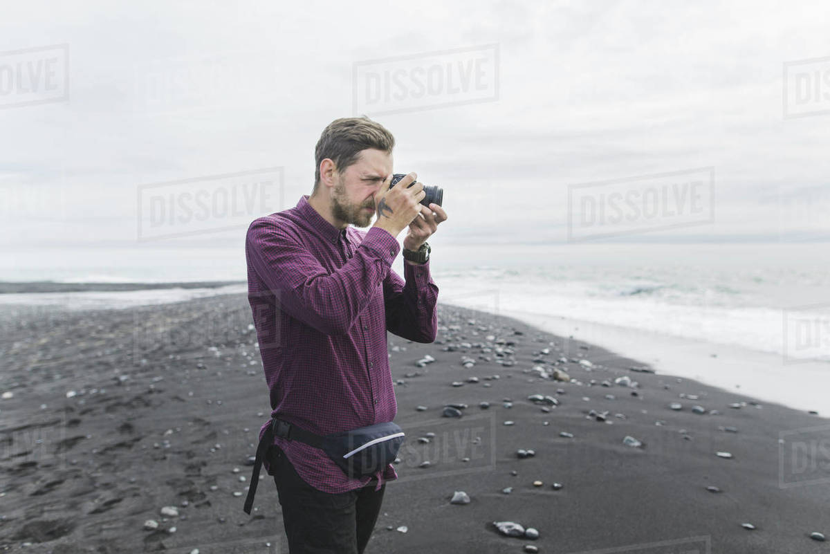Man taking photograph on beach in Iceland - Royalty-free Stock Photo ...