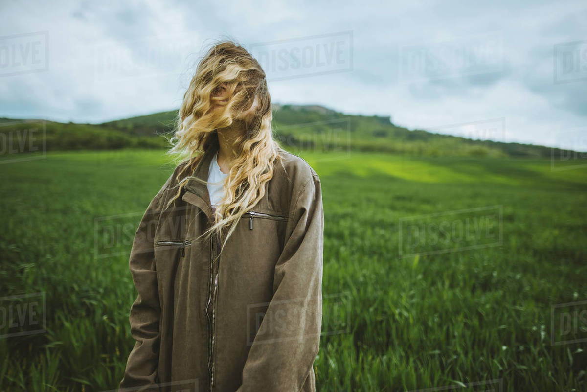 Windswept woman in field in Crimea, Ukraine - Stock Photo - Dissolve