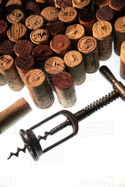 Corkscrew and collection of corks - Stock Photo - Dissolve