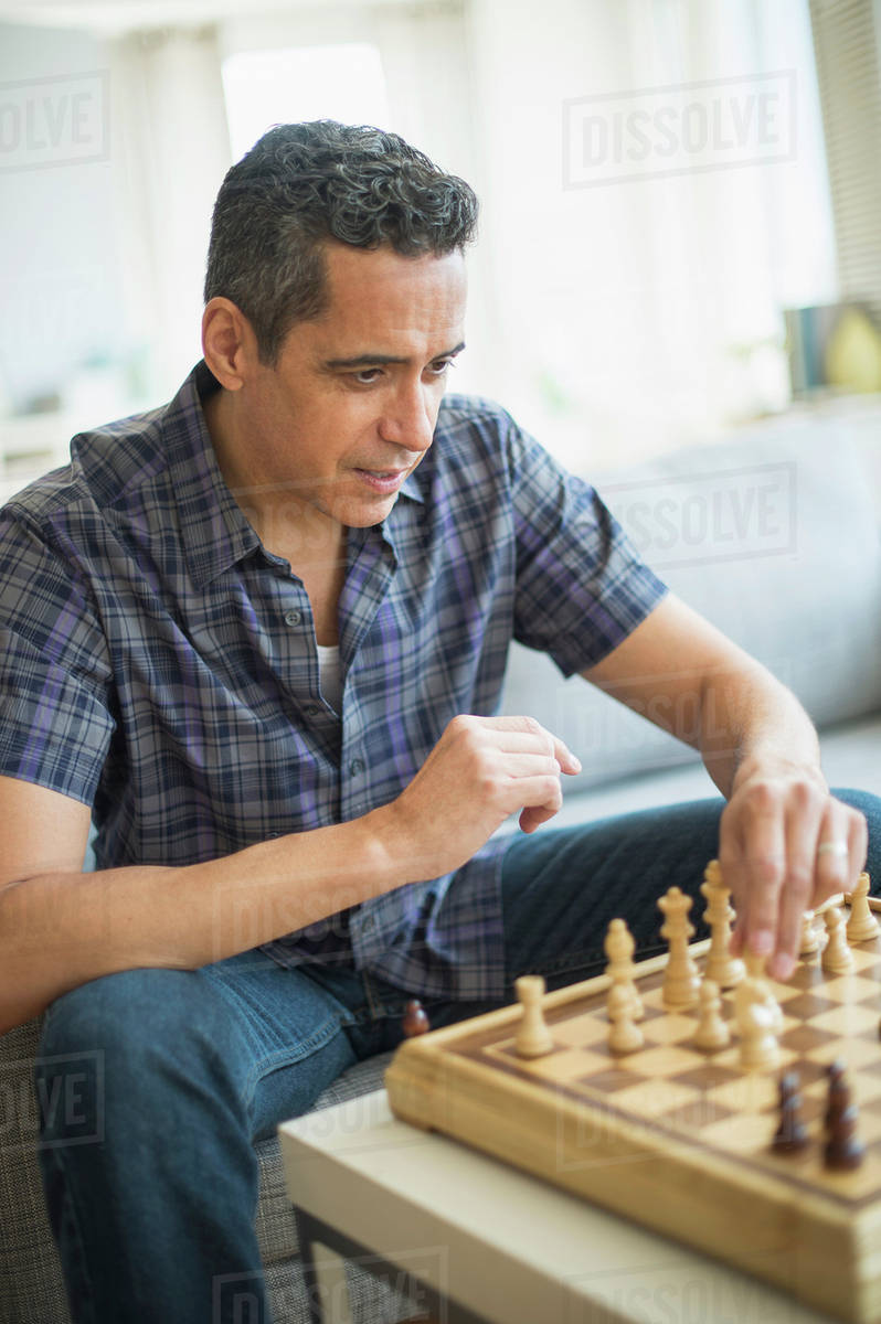 Man playing chess in living room - Royalty-free Stock Photo | Dissolve