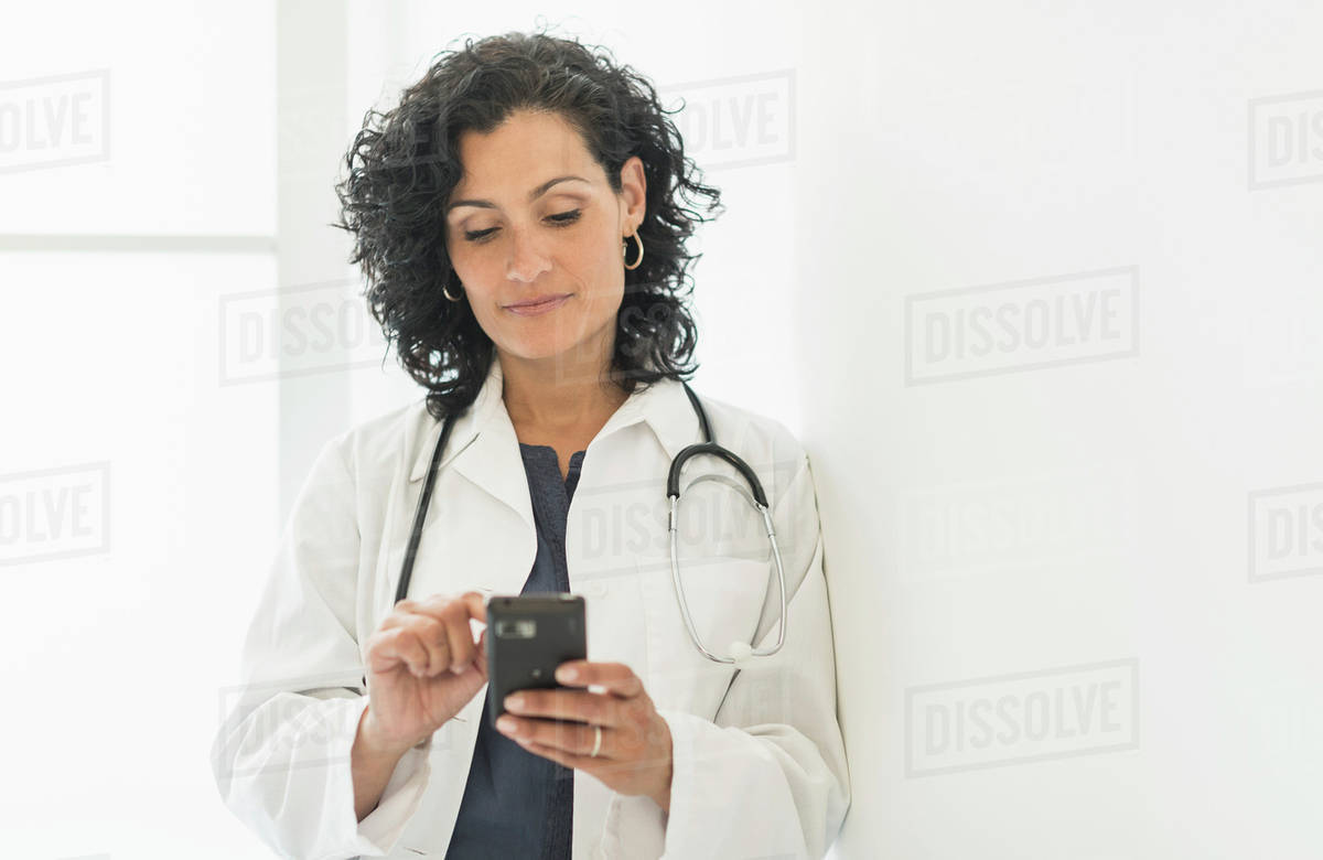 Female doctor using cell phone - Stock Photo - Dissolve