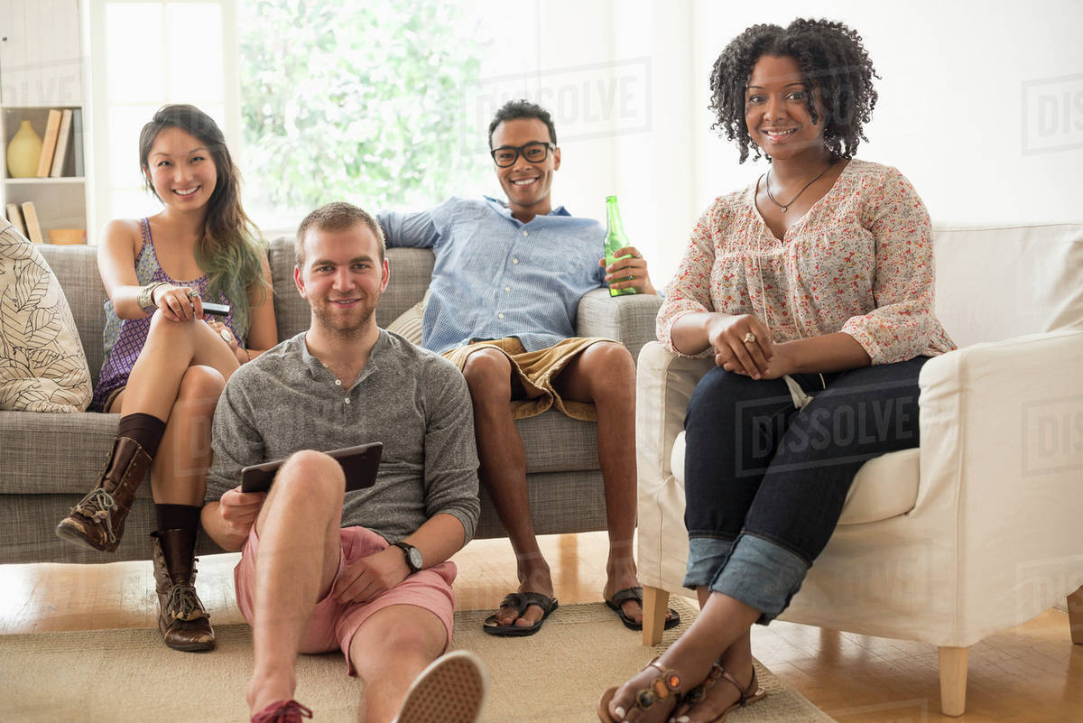 Portrait of group of friends sitting in living room - Stock Photo ...