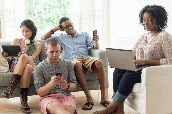 Friends hanging out in living room - Stock Photo - Dissolve