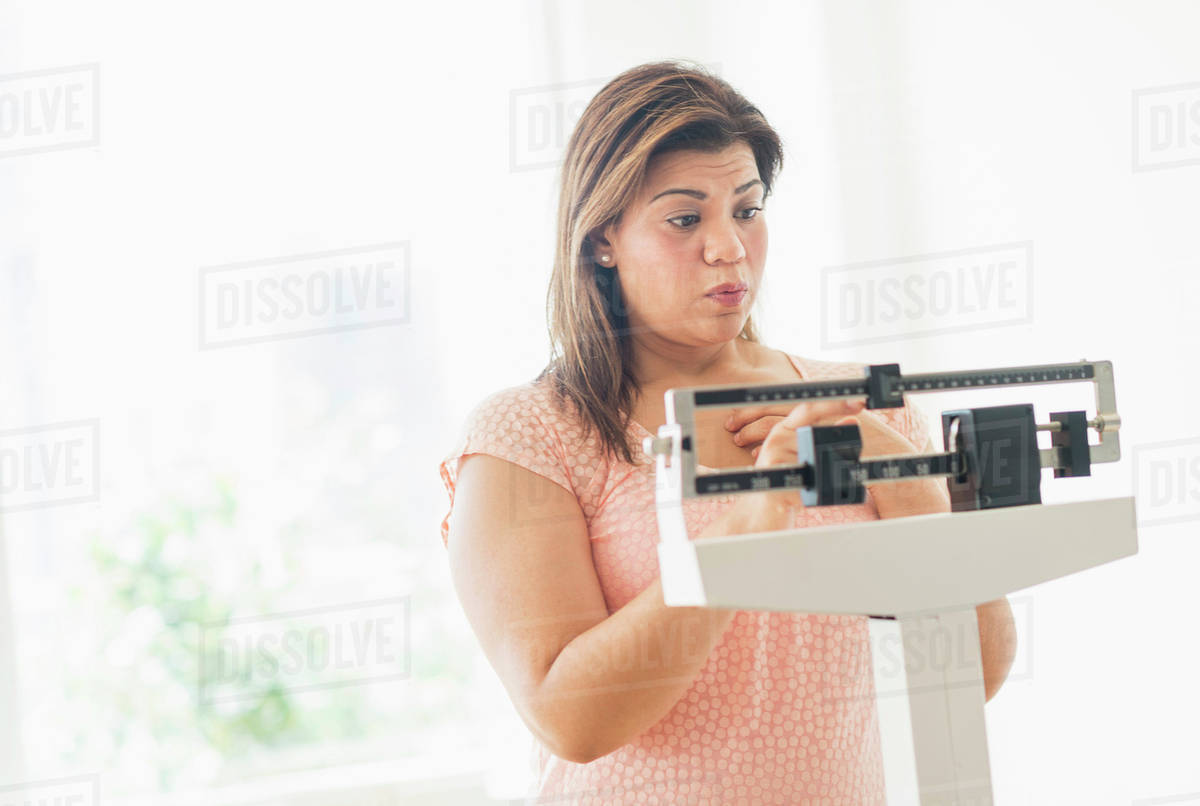 Woman standing on scale - Stock Photo - Dissolve