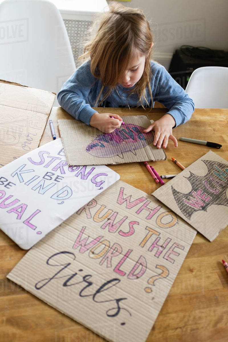 Girl coloring protest signs for women's march - Stock Photo - Dissolve