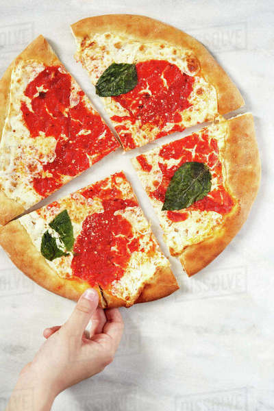 Hand grabbing pizza slice - Royalty-free Stock Photo | Dissolve