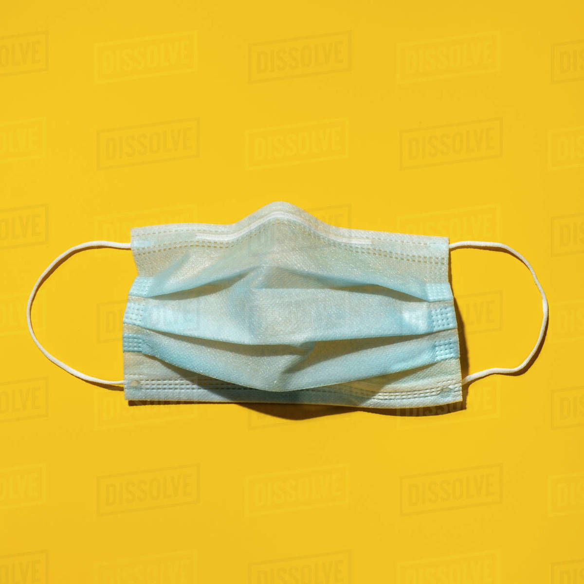 Surgical mask on yellow background - Royalty-free Stock Photo | Dissolve