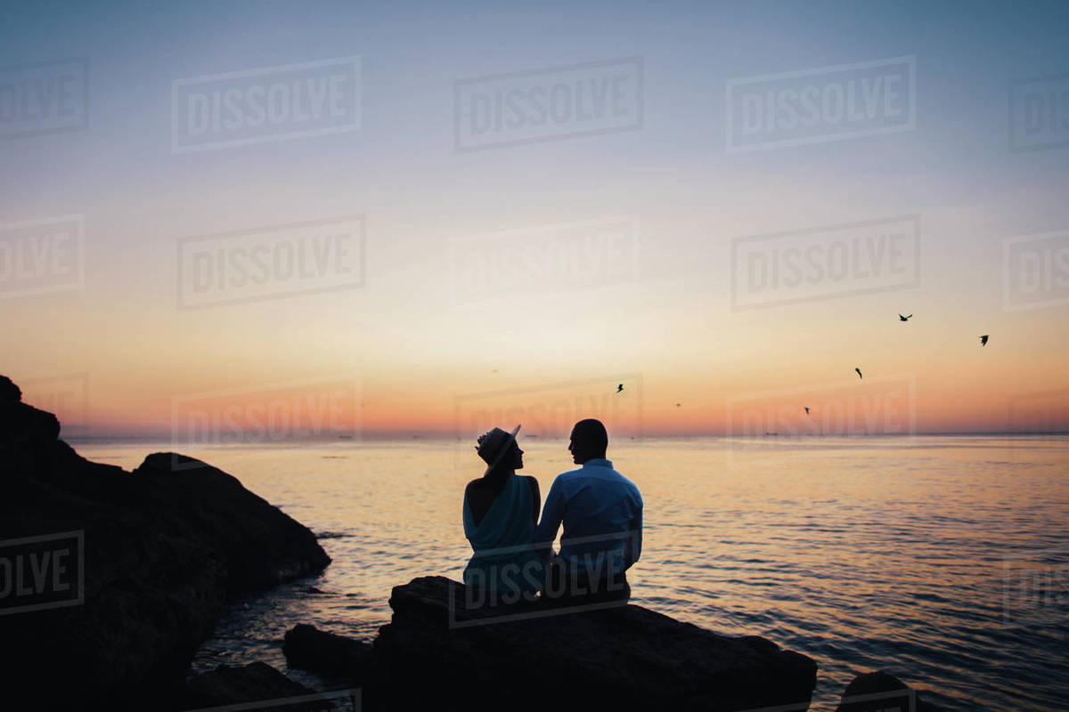 Couple on beach at sunset - Royalty-free Stock Photo | Dissolve