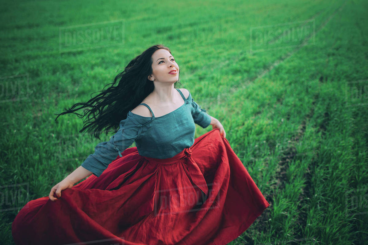Young woman dancing in field - Stock Photo - Dissolve