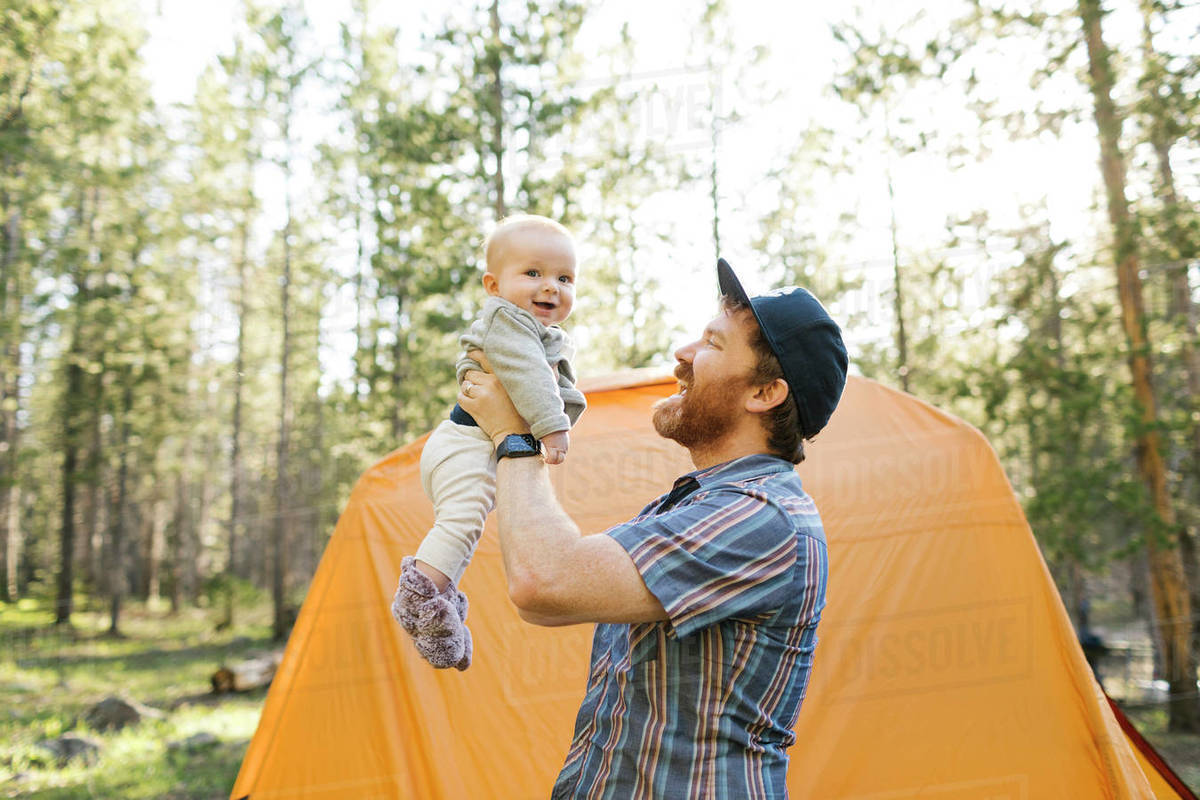 Father lifting baby boy(6-11 months) by tent in Uinta-Wasatch-Cache ...