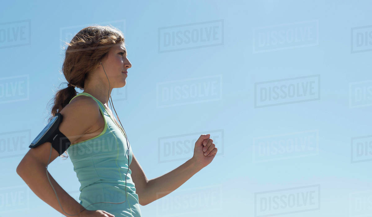 Side view of young woman jogging - Royalty-free Stock Photo | Dissolve