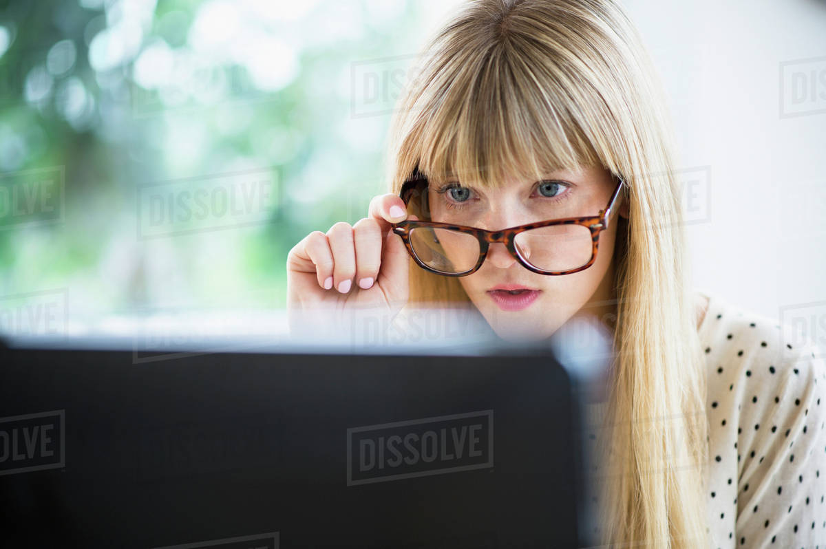 Woman wearing glasses working on computer - Stock Photo - Dissolve