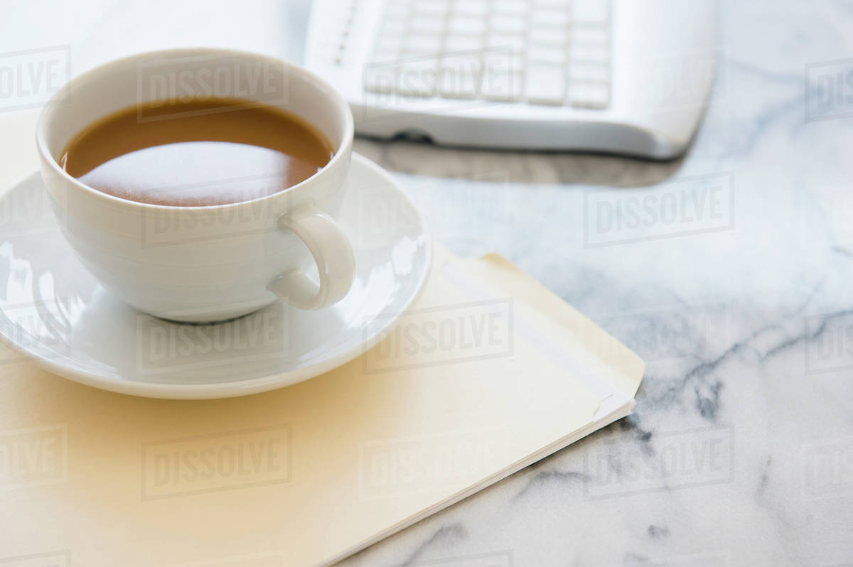 Studio shot of coffee cup, computer keyboard and files - Stock Photo ...